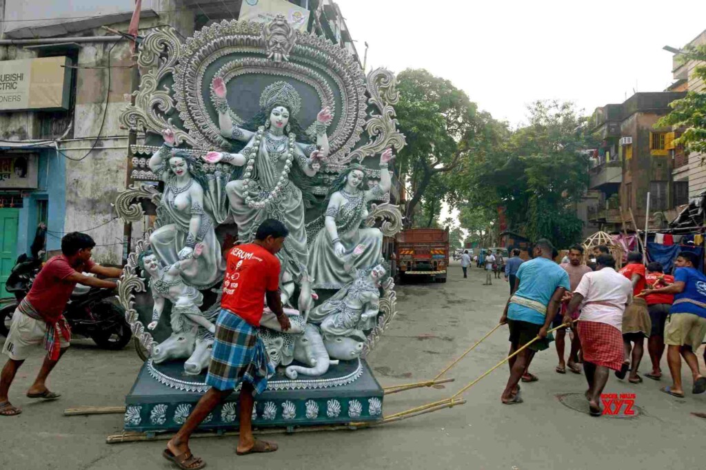 Kolkata: Labourers pull a cart loaded with an idol of Goddess Kali at ...